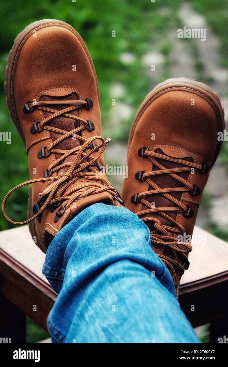 Brown boots and jeans on the legs. Legs are crossed on the stool Stock ...