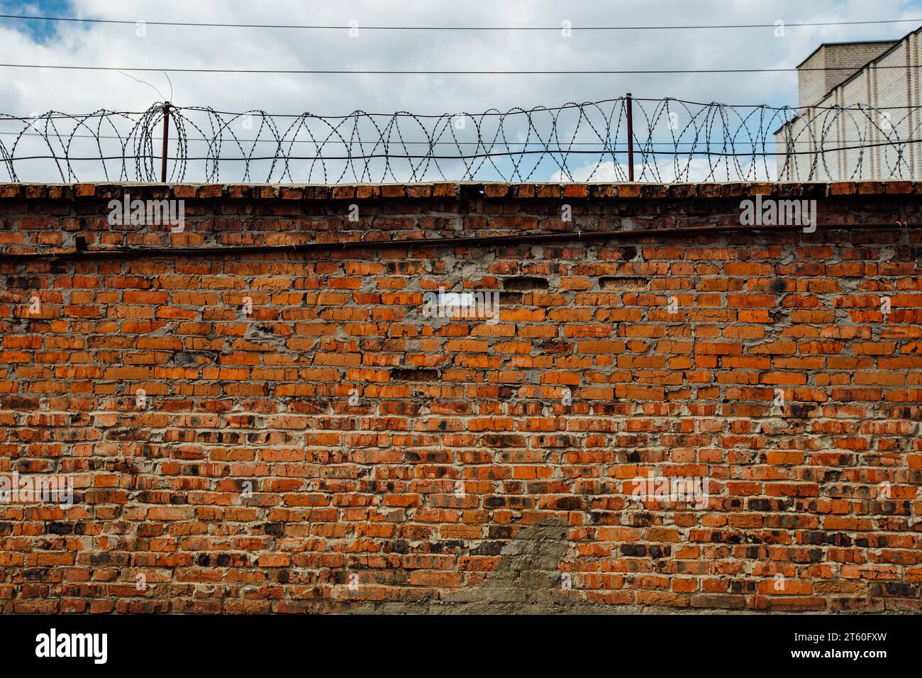 Red brick wall with barbed wire. Concept of prison, border, colony etc Stock Photo - Alamy