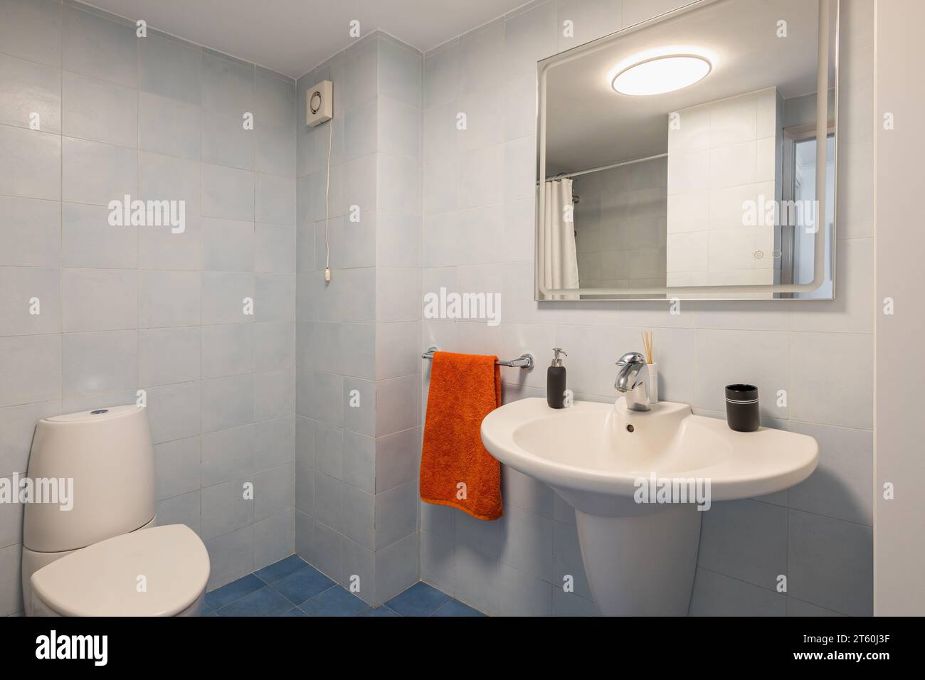 Mirror over sink and toilet bowl in tiled modern bathroom Stock Photo ...