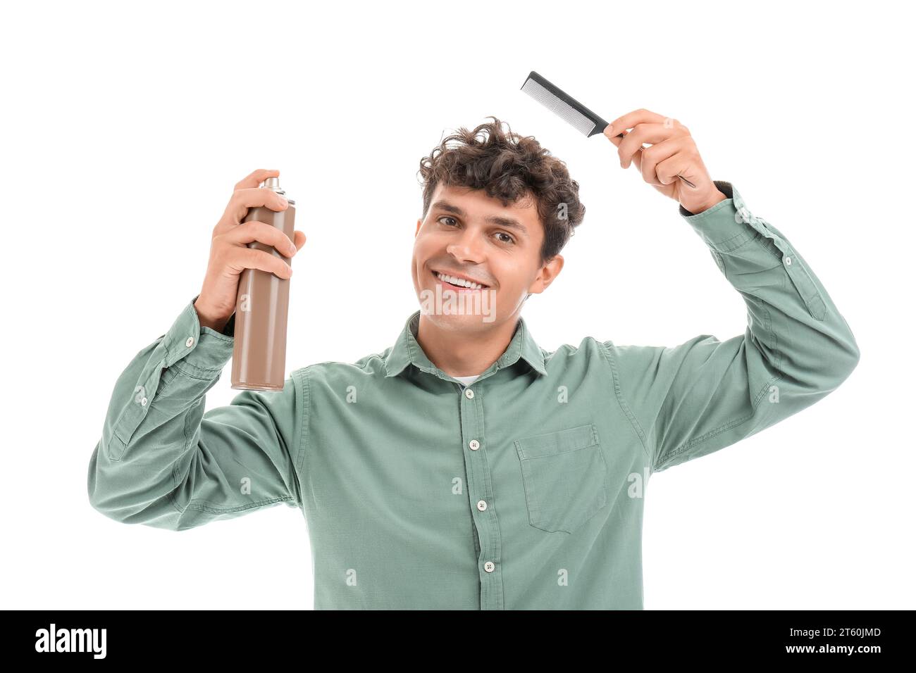 Handsome young man applying hair spray on his curly hair against white ...