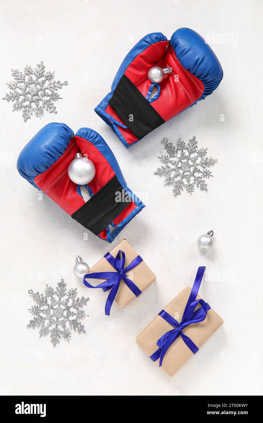 Boxing gloves with Christmas gift boxes and snowflakes on white ...