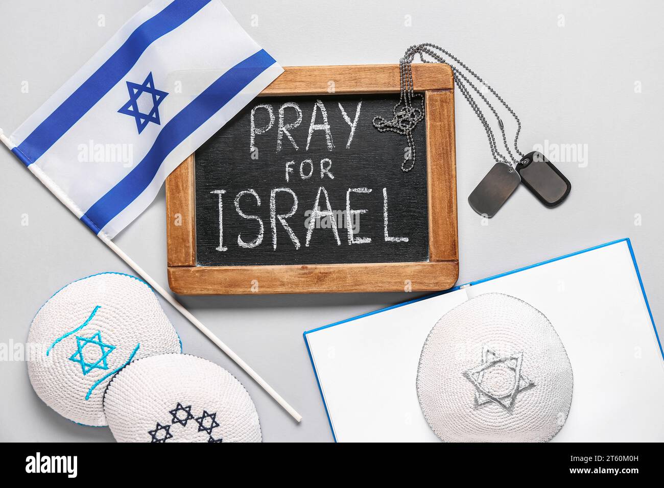 Chalkboard with text PRAY FOR ISRAEL, Jewish hats, flag and dog tags on ...