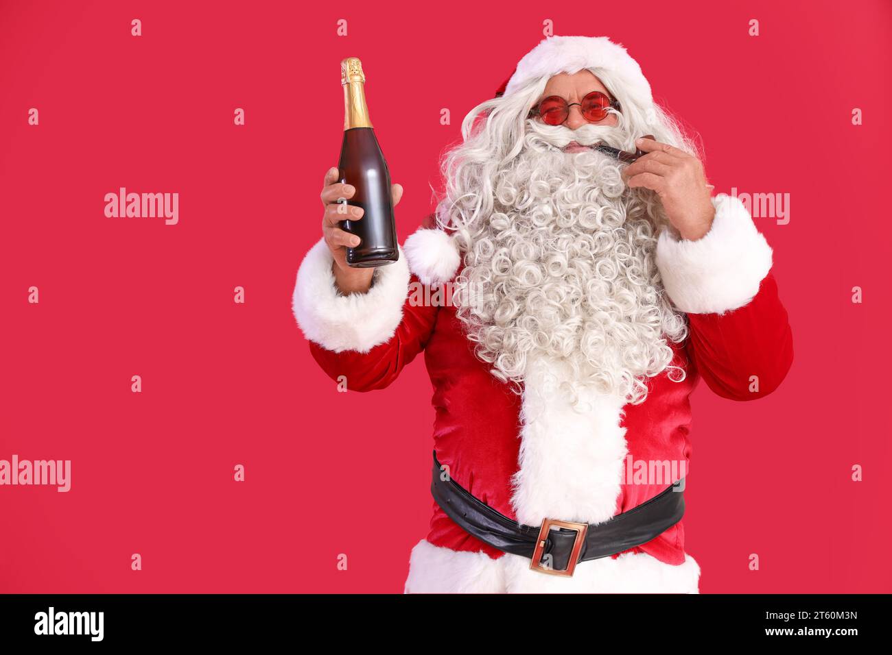 Santa Claus with smoking pipe and bottle of champagne on red background ...