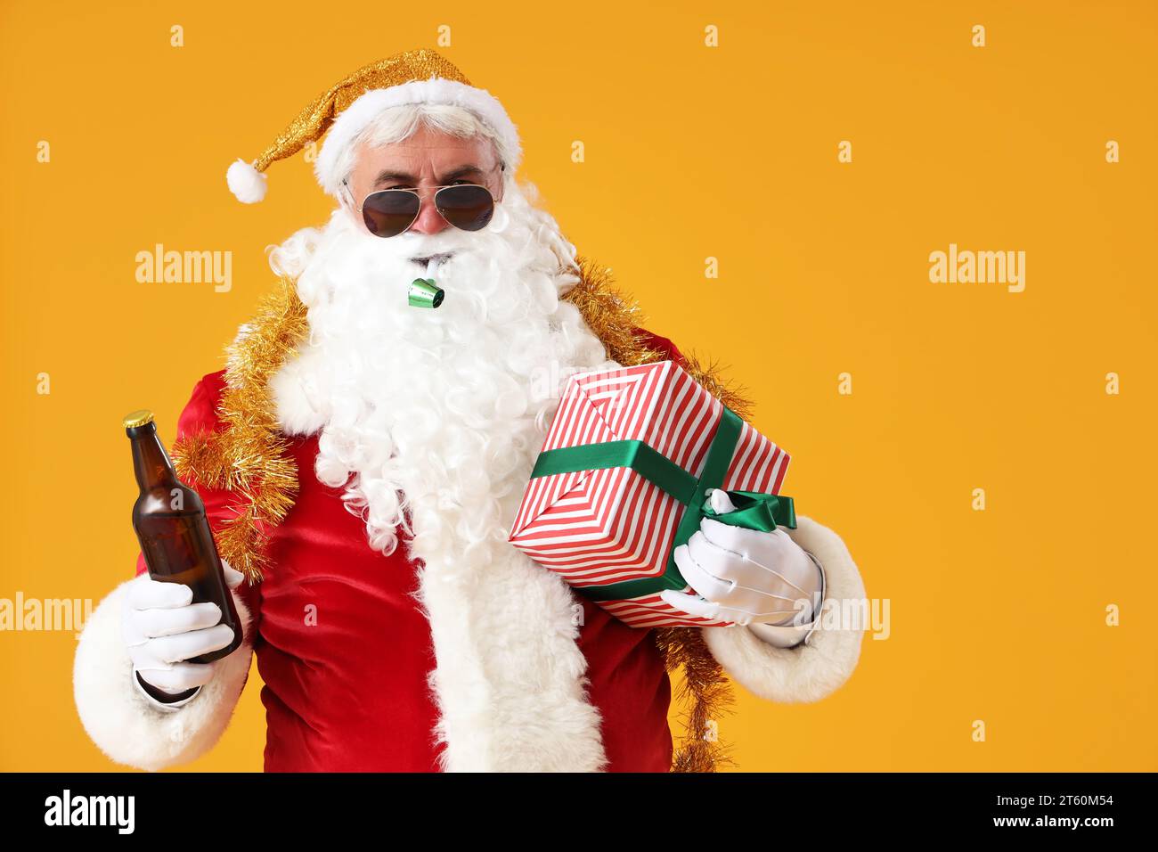 Cool Santa Claus with beer and Christmas gift on yellow background ...