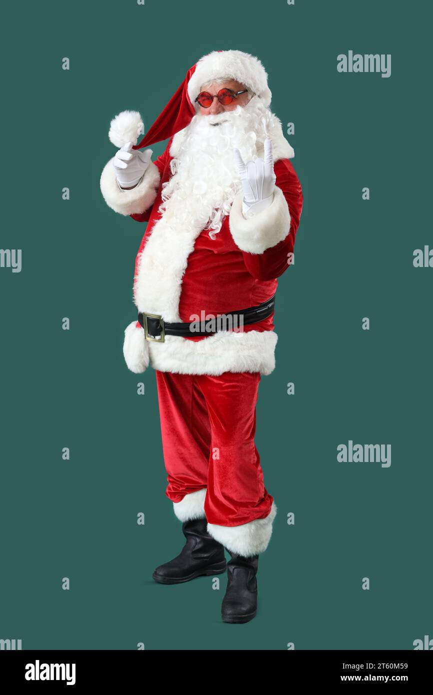 Cool Santa Claus showing "devil horns" on green background Stock Photo ...