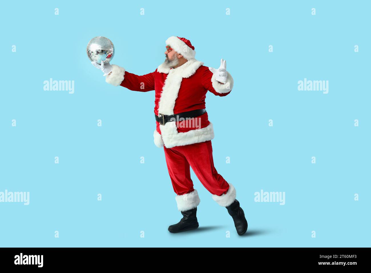 Funny Santa Claus with disco ball dancing on blue background Stock ...