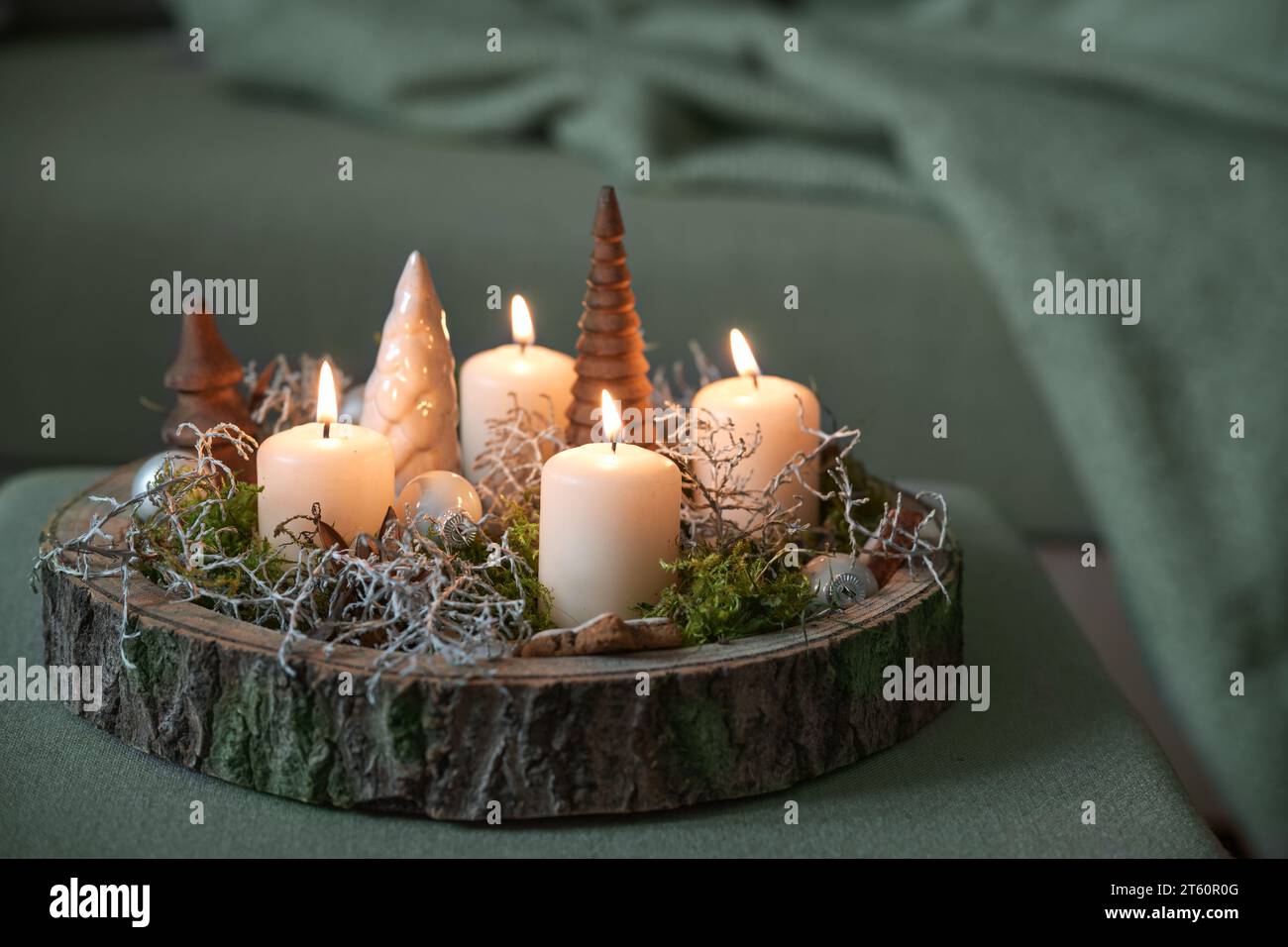 Christmas decoration and white advent candles and on a rustic tree tray ...