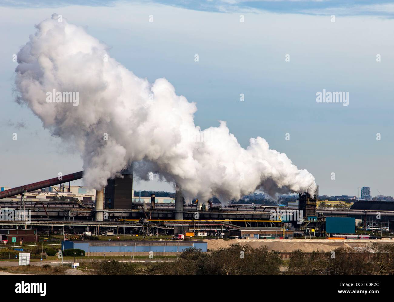Industrial factory with heavy smoke from chimneys against a blue sky ...