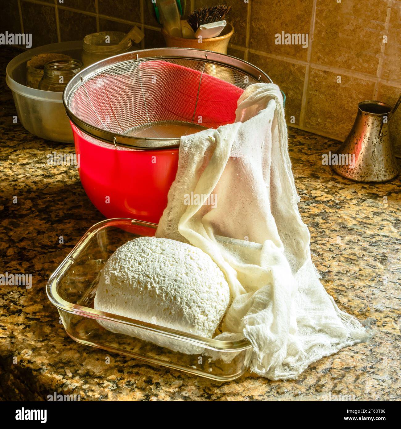 Soft cheese in glass container after it was strained from whey using ...
