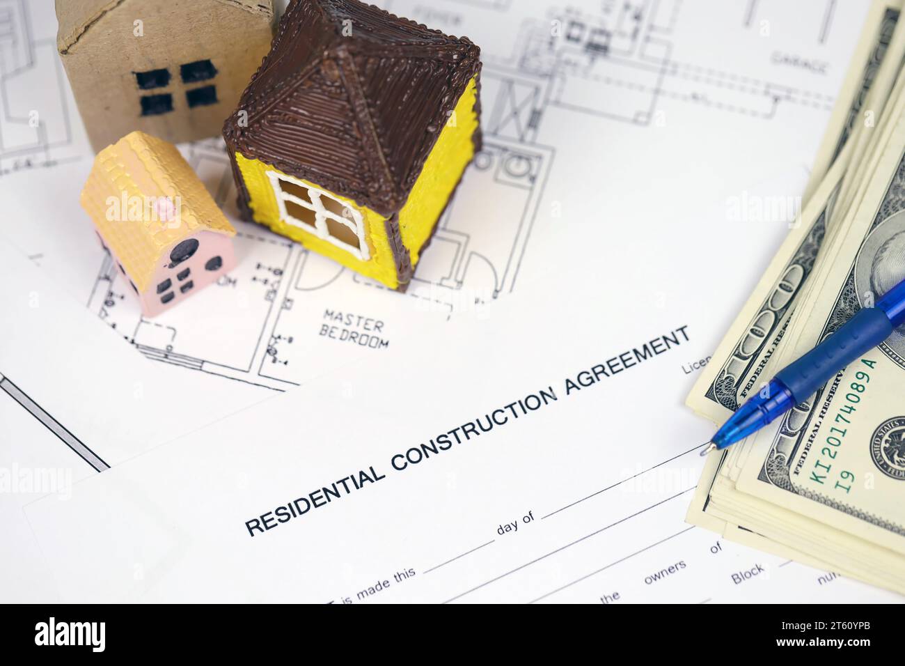 Residential construction agreement ready to sign with small toy houses ...