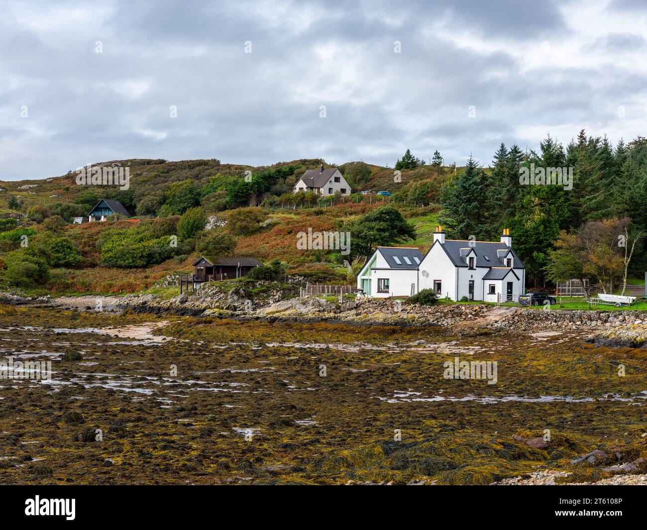 A typical white Scottish house shown in a Scottish landscape, in a bay ...