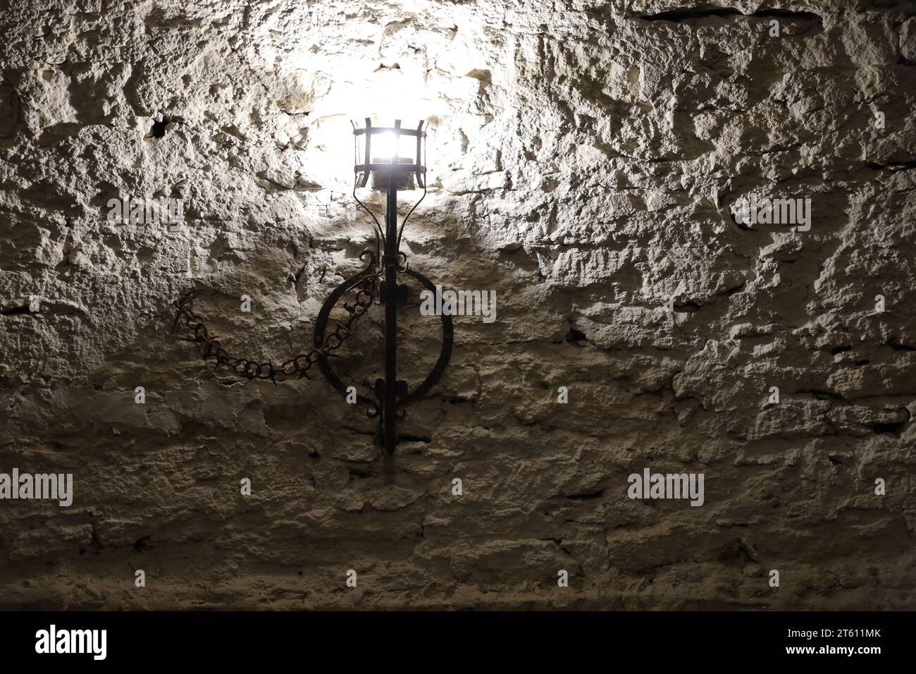 Lighted medieval castle torch hanging on a stone wall, vintage objects ...