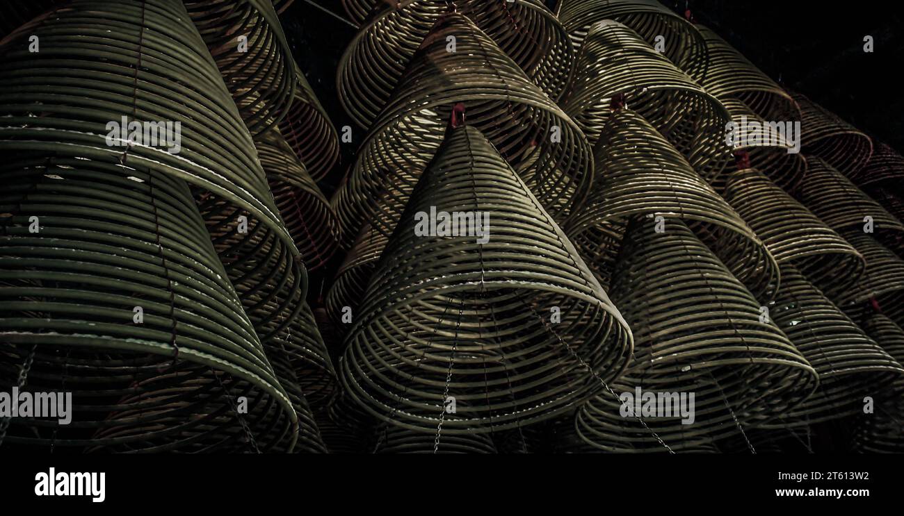 Multiple large yellow incense coils hanging in stacks from the Ceiling ...