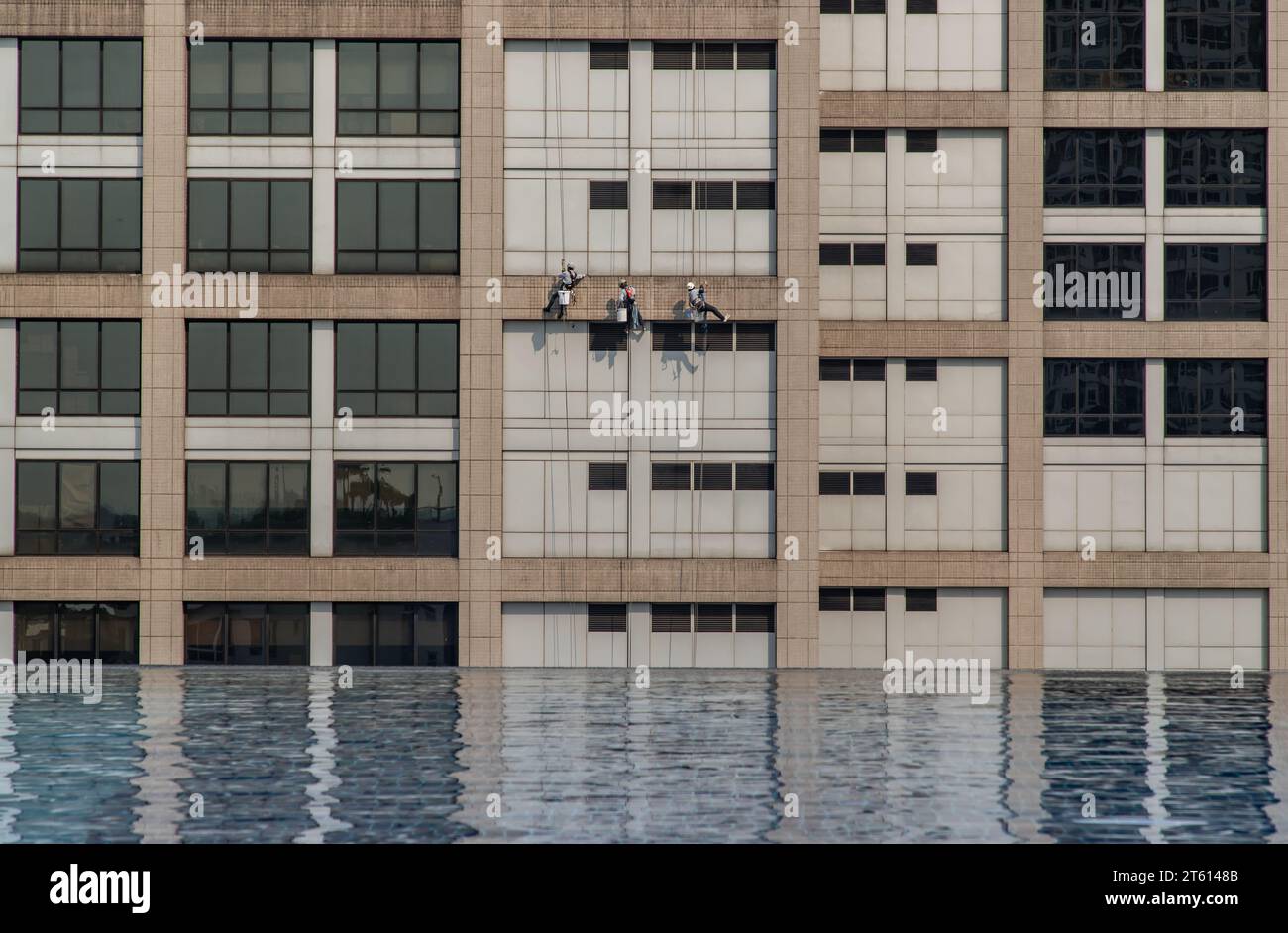 Group of workers cleaning windows service on high rise office building ...