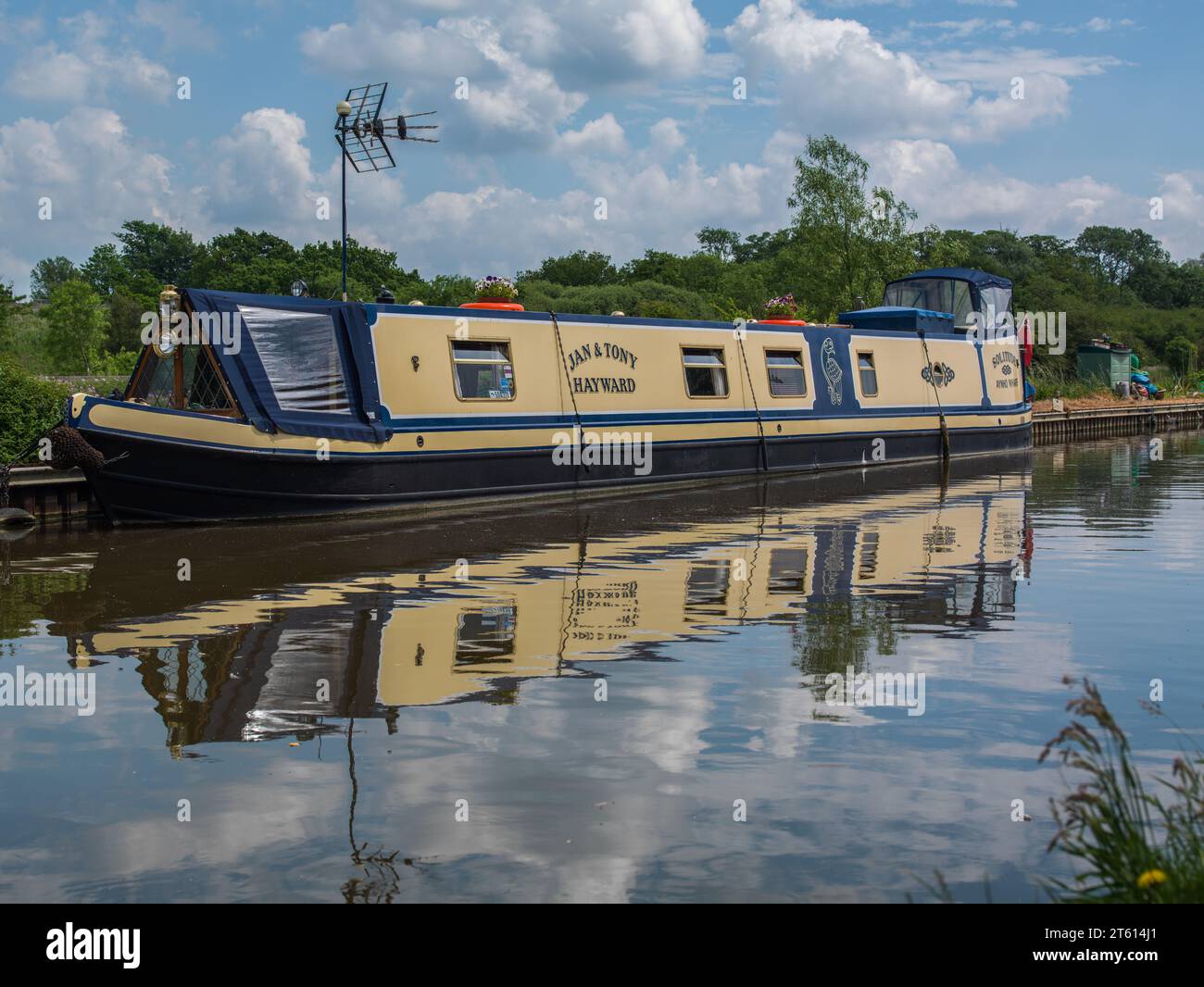 A narrow boat moored at Anyhow Wharf, Oxfordshire, with a reflection ...