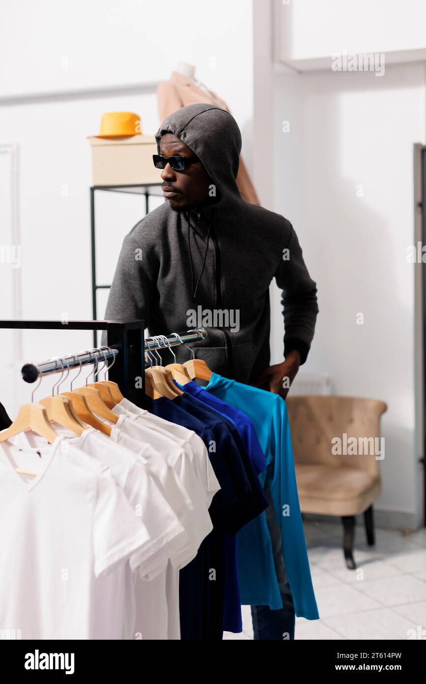 African american robber choosing to steal fashionable merchandise ...