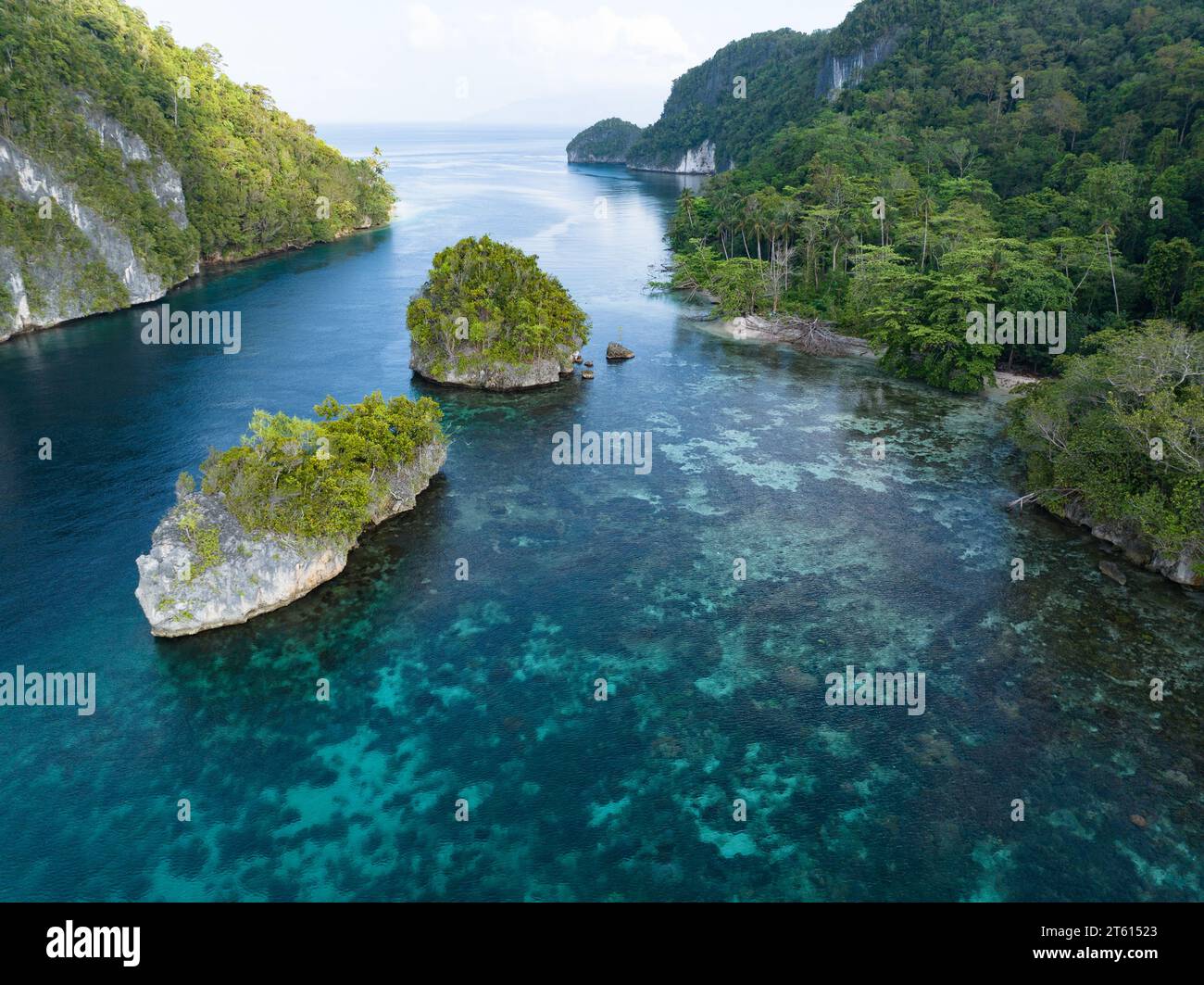 A shallow coral reef grows along the edge of a scenic island in Alyui ...