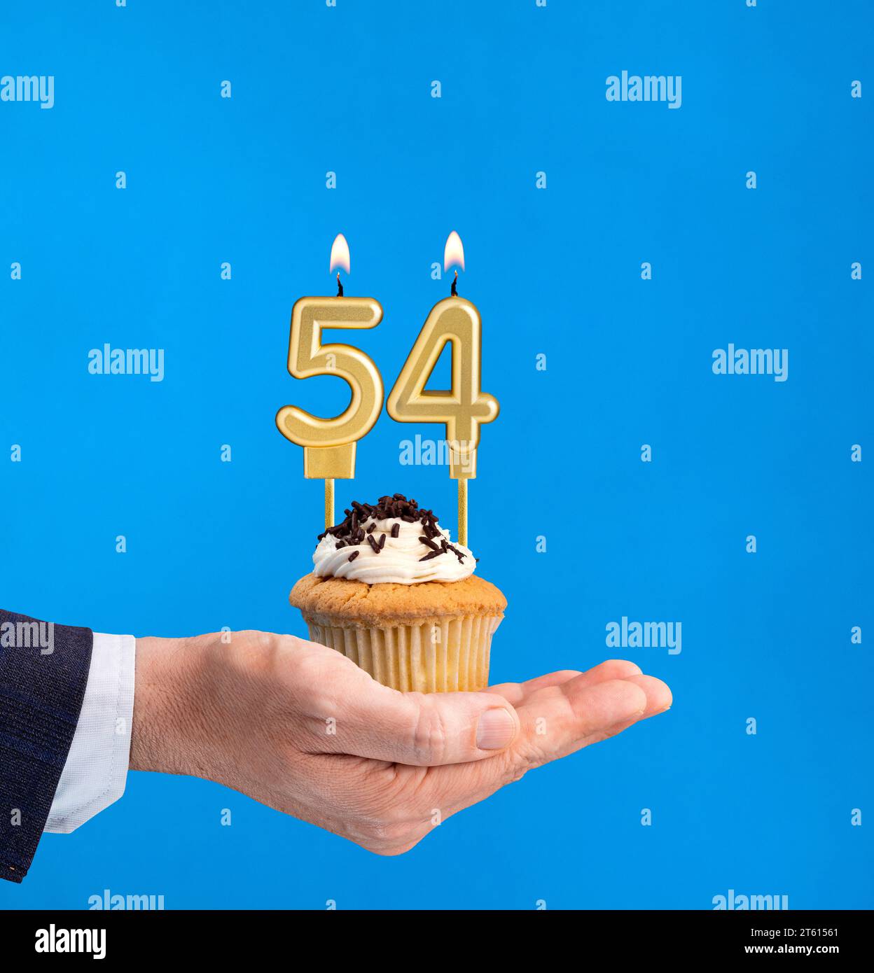 Hand delivering birthday cupcake - Candle number 54 on blue background ...