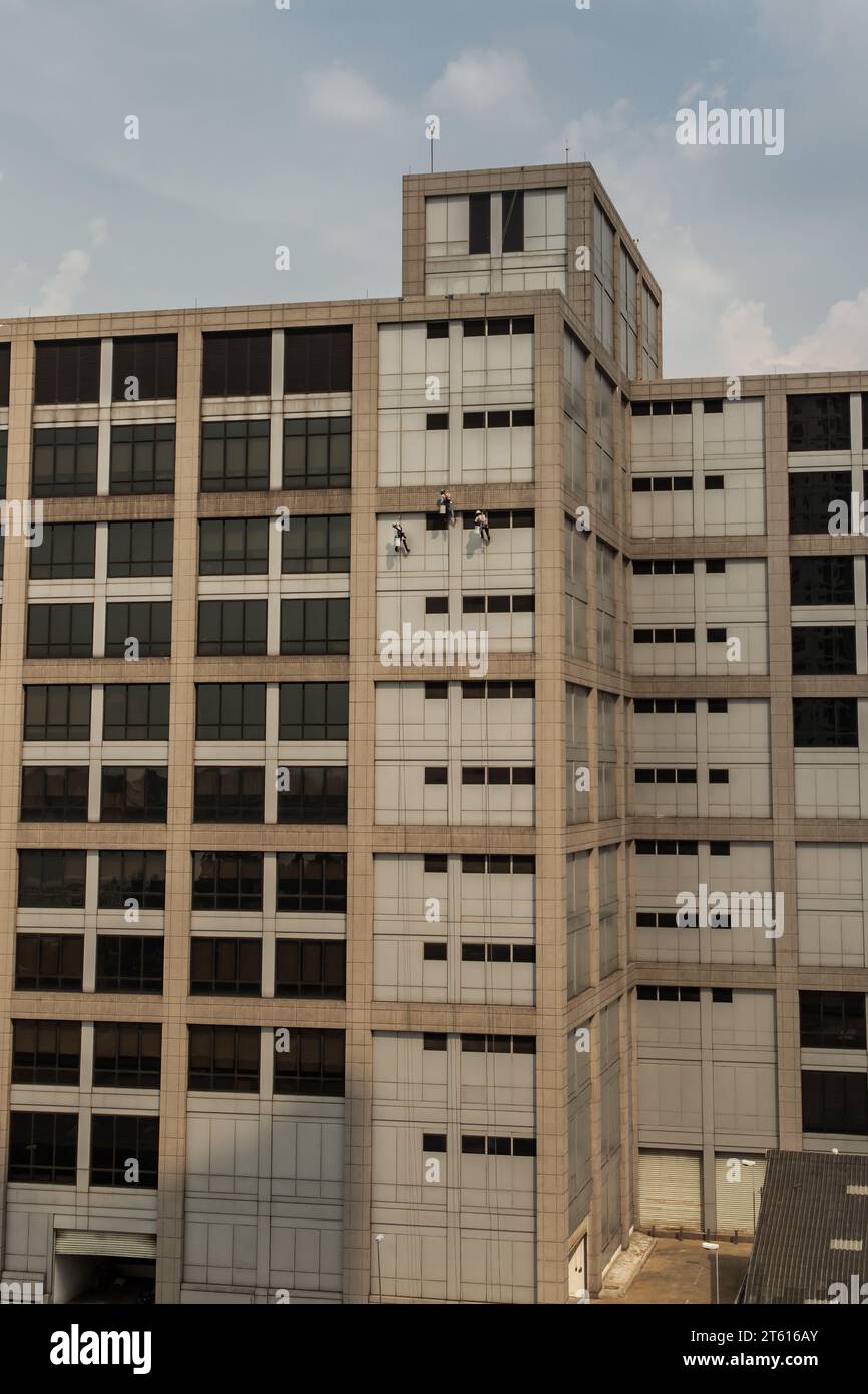 Group of workers cleaning windows service on high rise office building ...