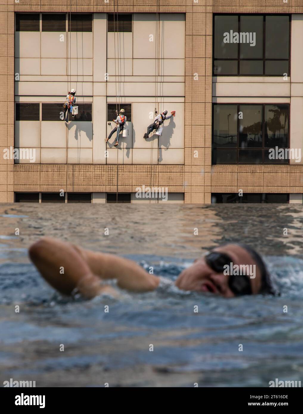 Group of workers cleaning windows service on high rise office building ...