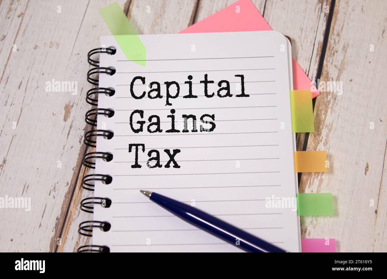 Closeup on businessman holding a card with text CAPITAL GAINS TAX ...
