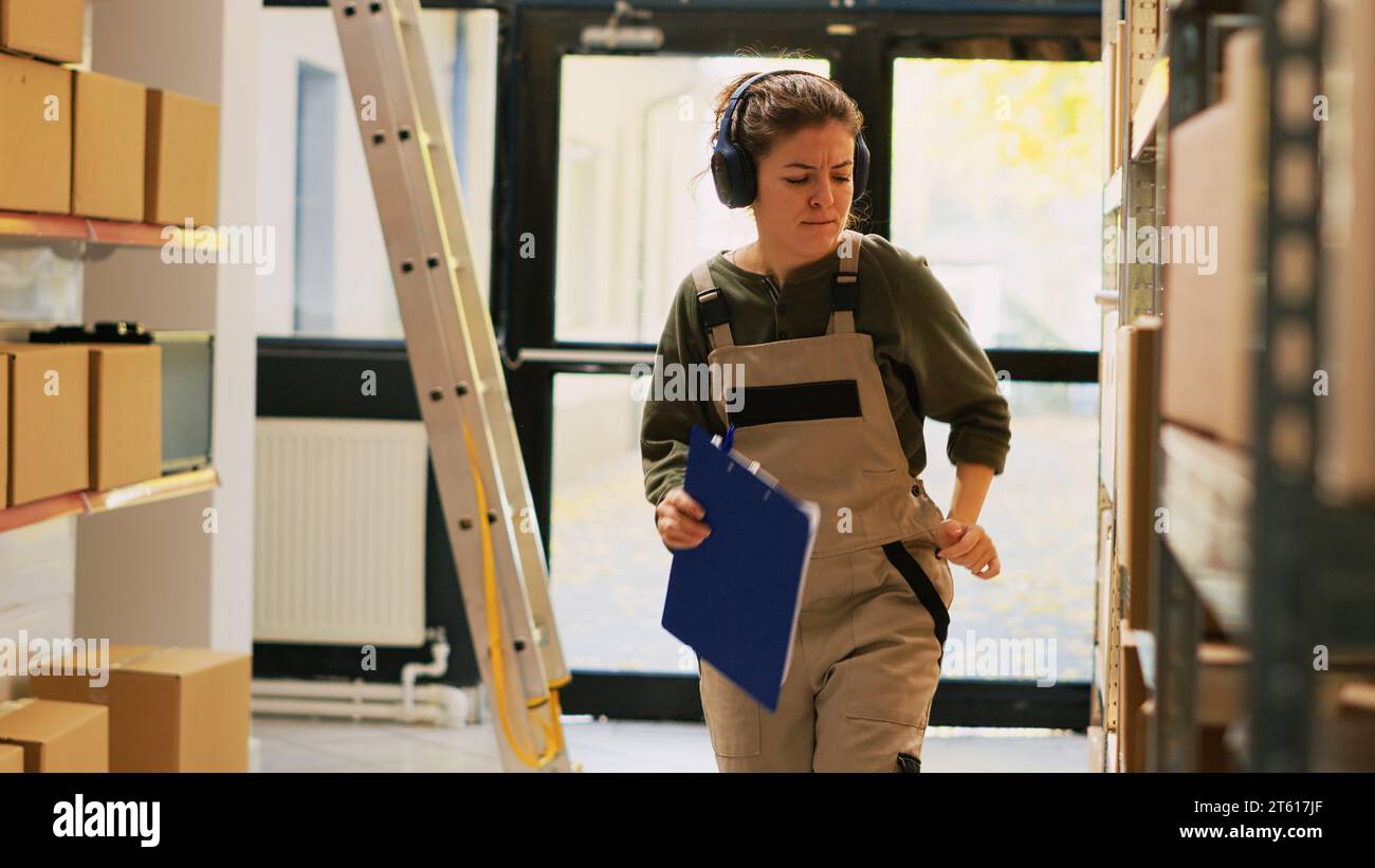 Depot manager having fun in warehouse, reviewing inventory list and ...