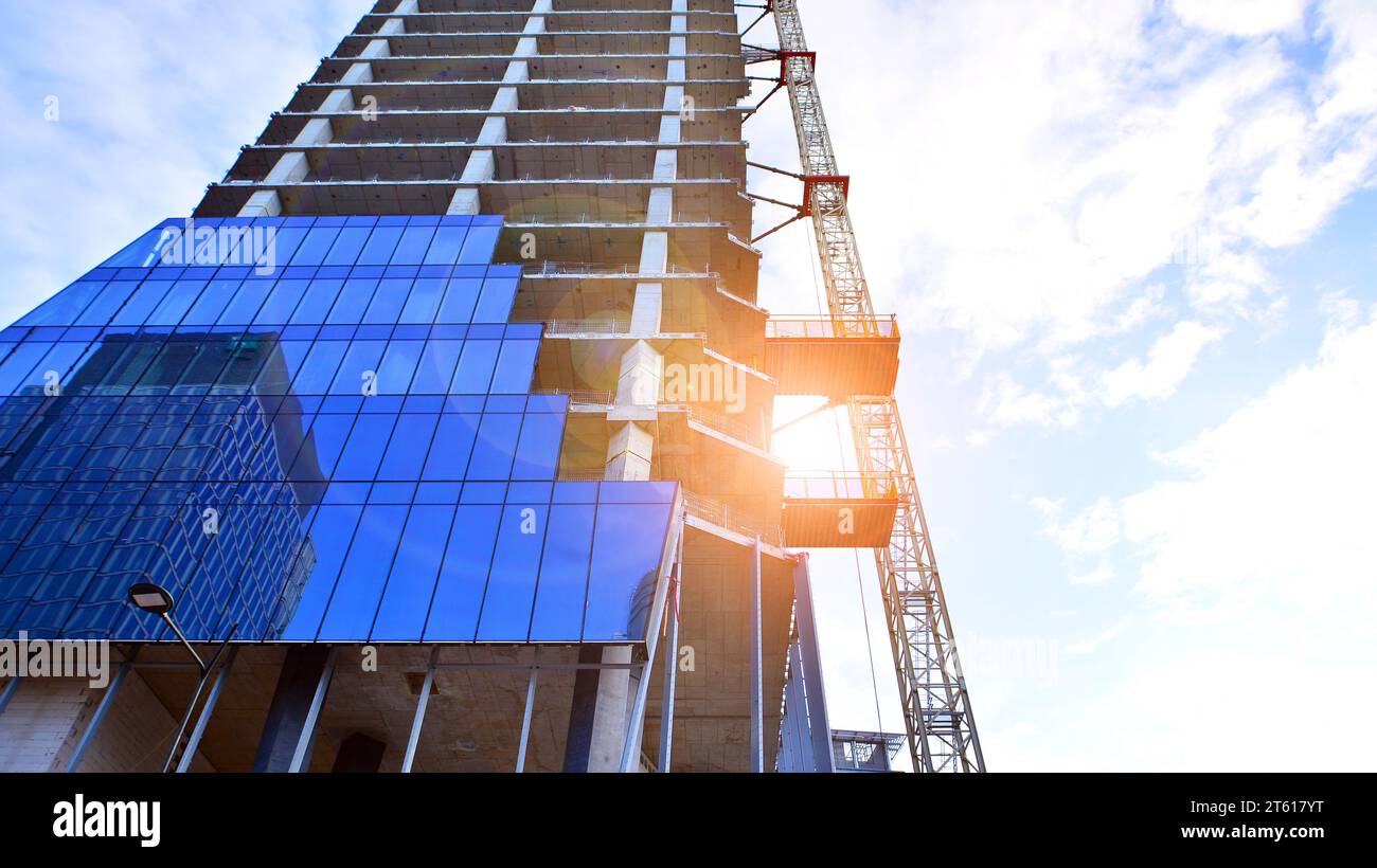 High rise building under construction. Installation of glass facade ...
