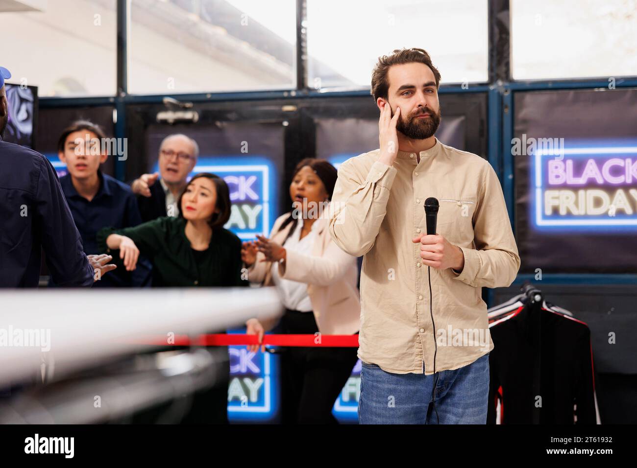 Young man TV news reporter standing with microphone against angry crazy ...