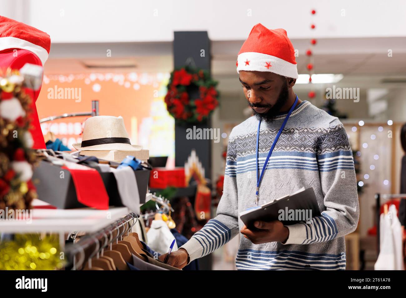 African american man counting hangers in clothing store, working on ...