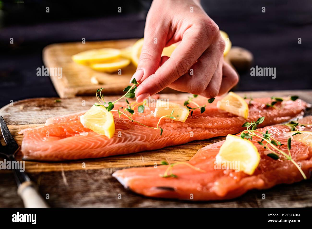 girl decorating at fillet trout red fish for cooking a healthy dinner ...