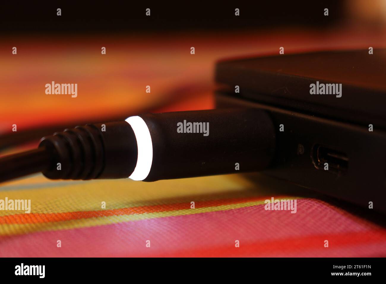 laptop charging cable lit up and plugged into a laptop device Stock ...