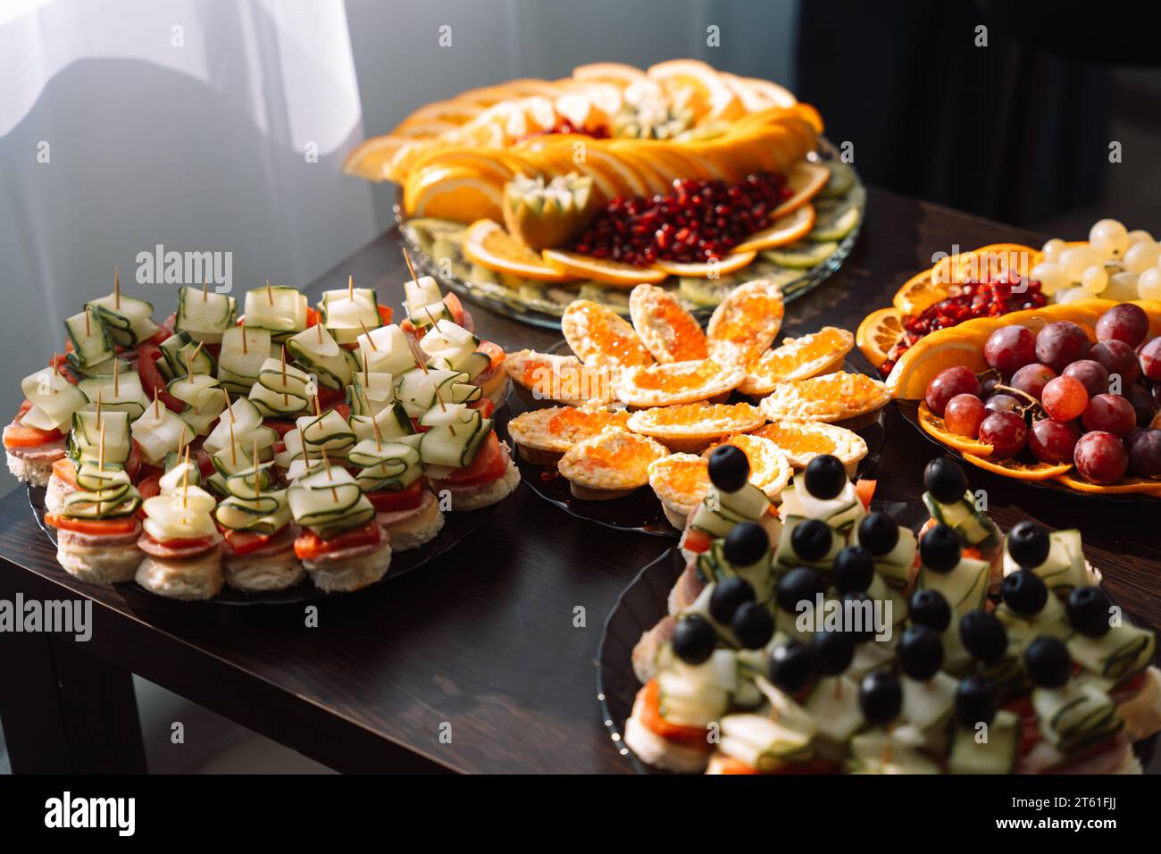 Cold appetizers and sliced fruits in plates on a small table Stock ...