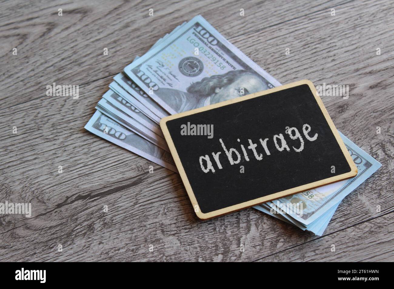 Closeup image of chalkboard with text ARBITRAGE and money. Business and financial concept Stock ...