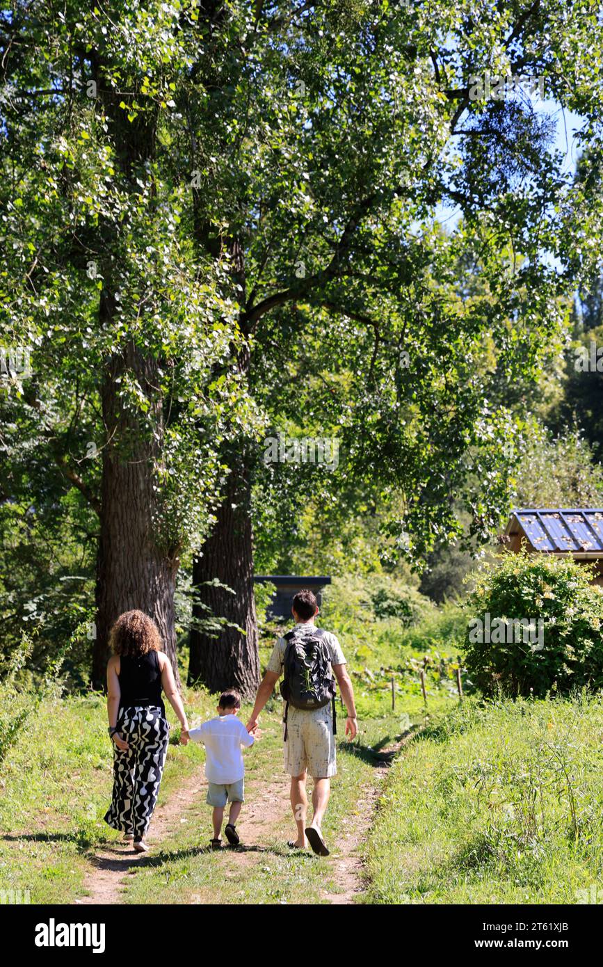 Family walk, child, father and mother, along the Vézère river in the ...