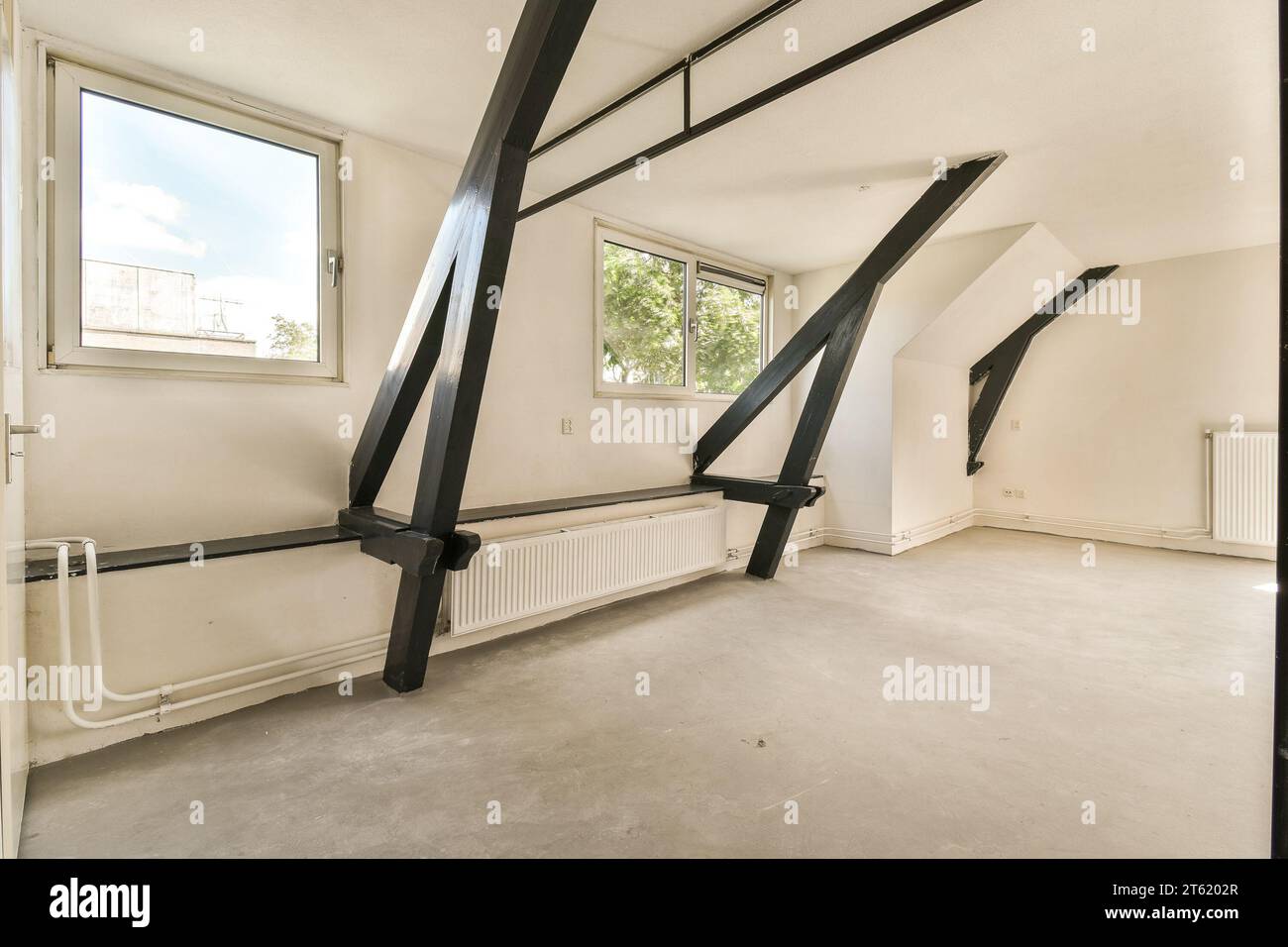 an empty room with white walls and black metal pipes on the wall, there ...