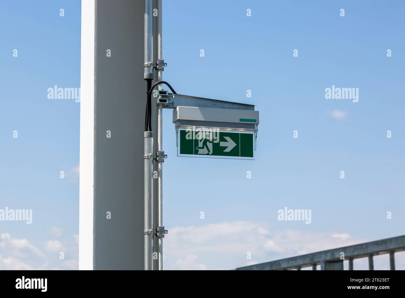 Emergency exit indicator on a metal pillar Stock Photo - Alamy