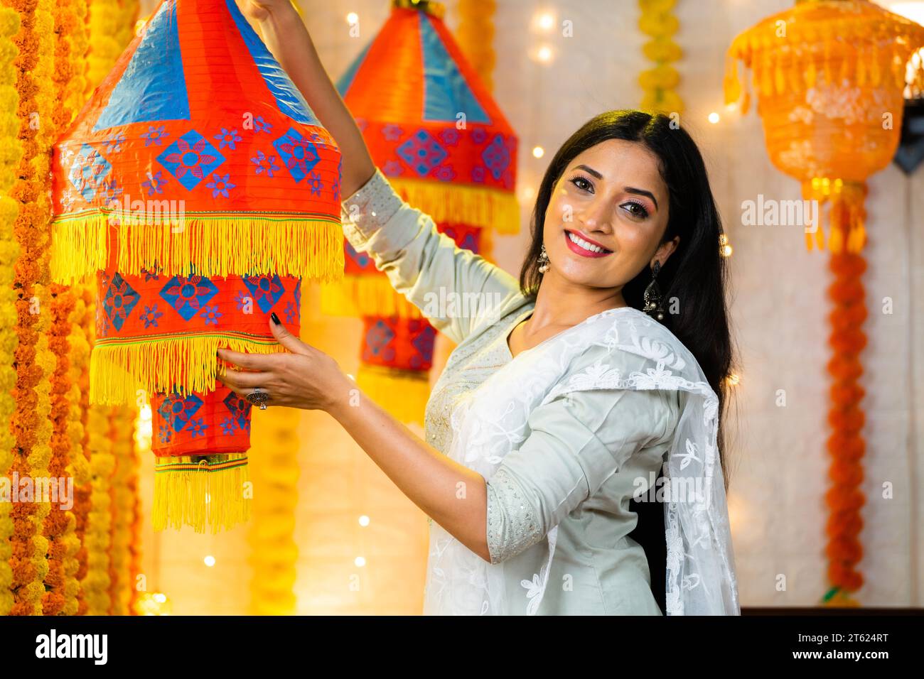 Happy smiling indian young girl decorating lantern akash butti for ...