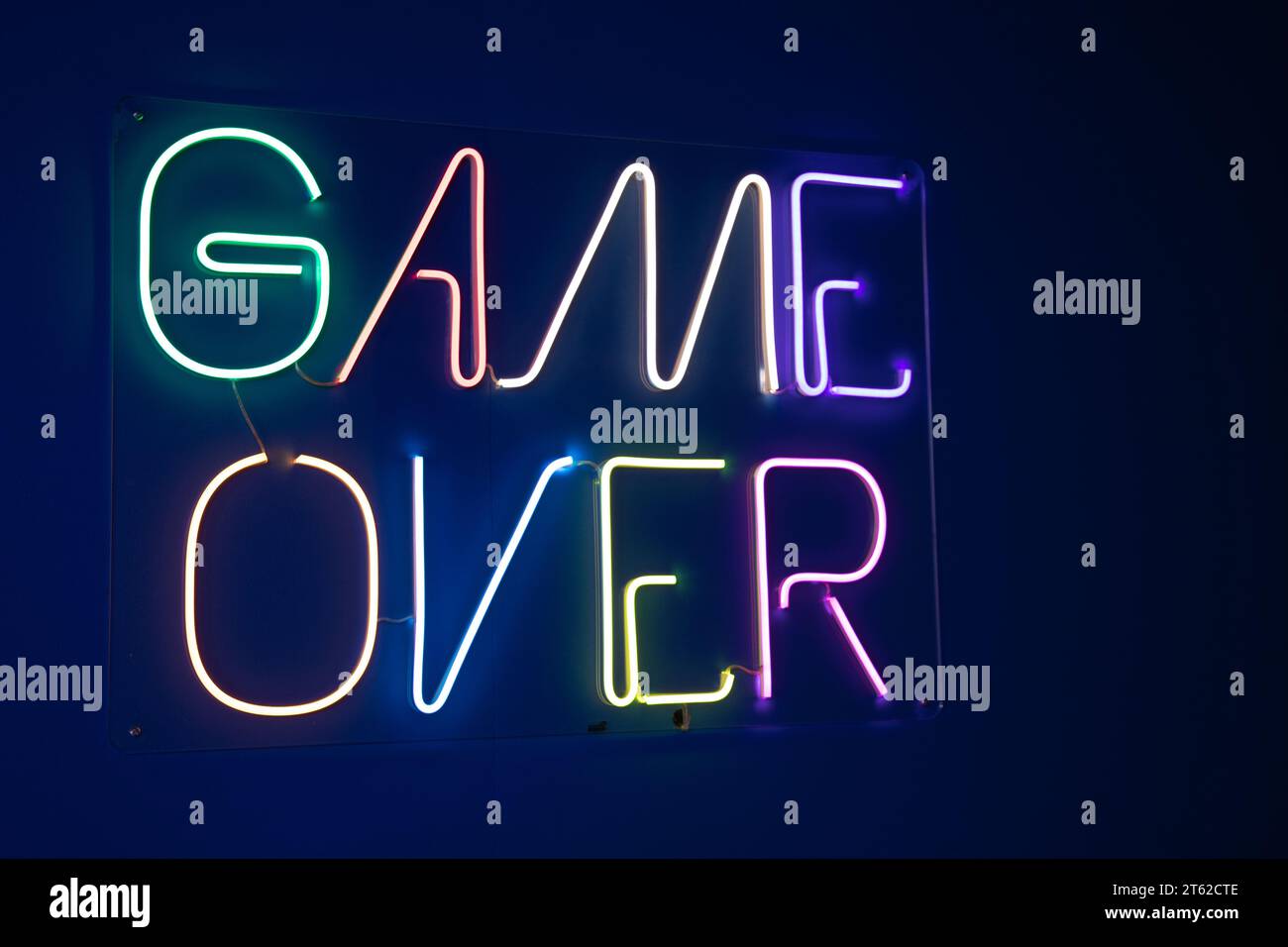 game over neon sign color on a dark wall background Stock Photo - Alamy