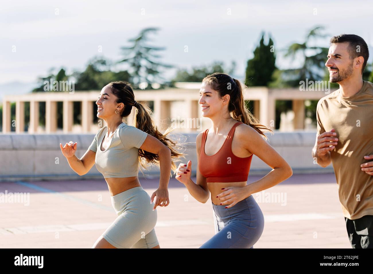 Three young friends running together outdoors Stock Photo - Alamy