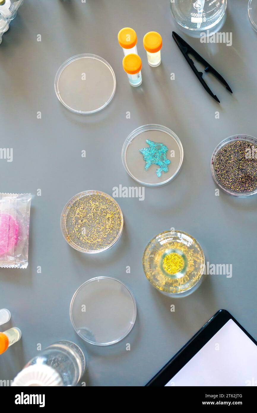 Laboratory instrument set and glitter samples in petri dishes over a ...
