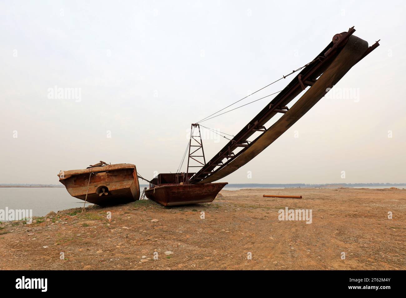 Simple sand dredger by river bank Stock Photo - Alamy
