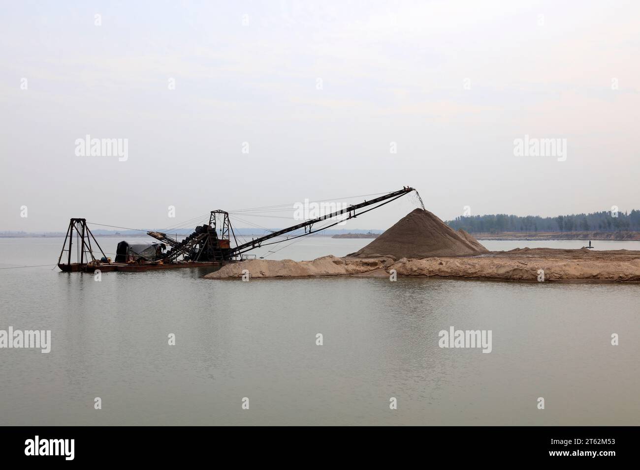 Simple sand dredger by river bank Stock Photo - Alamy