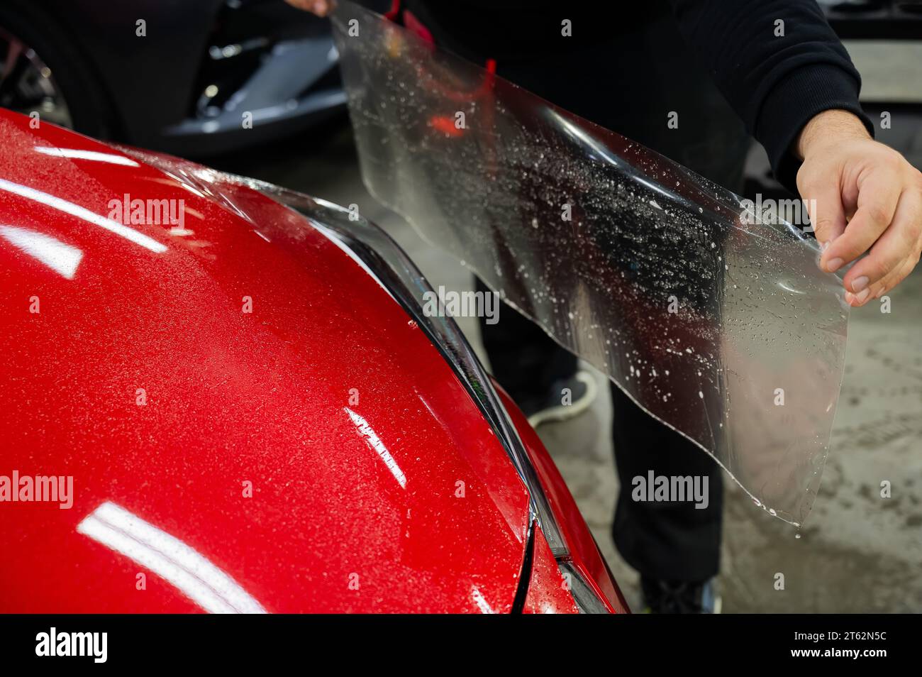 The process of applying protective vinyl film to car headlights in ...