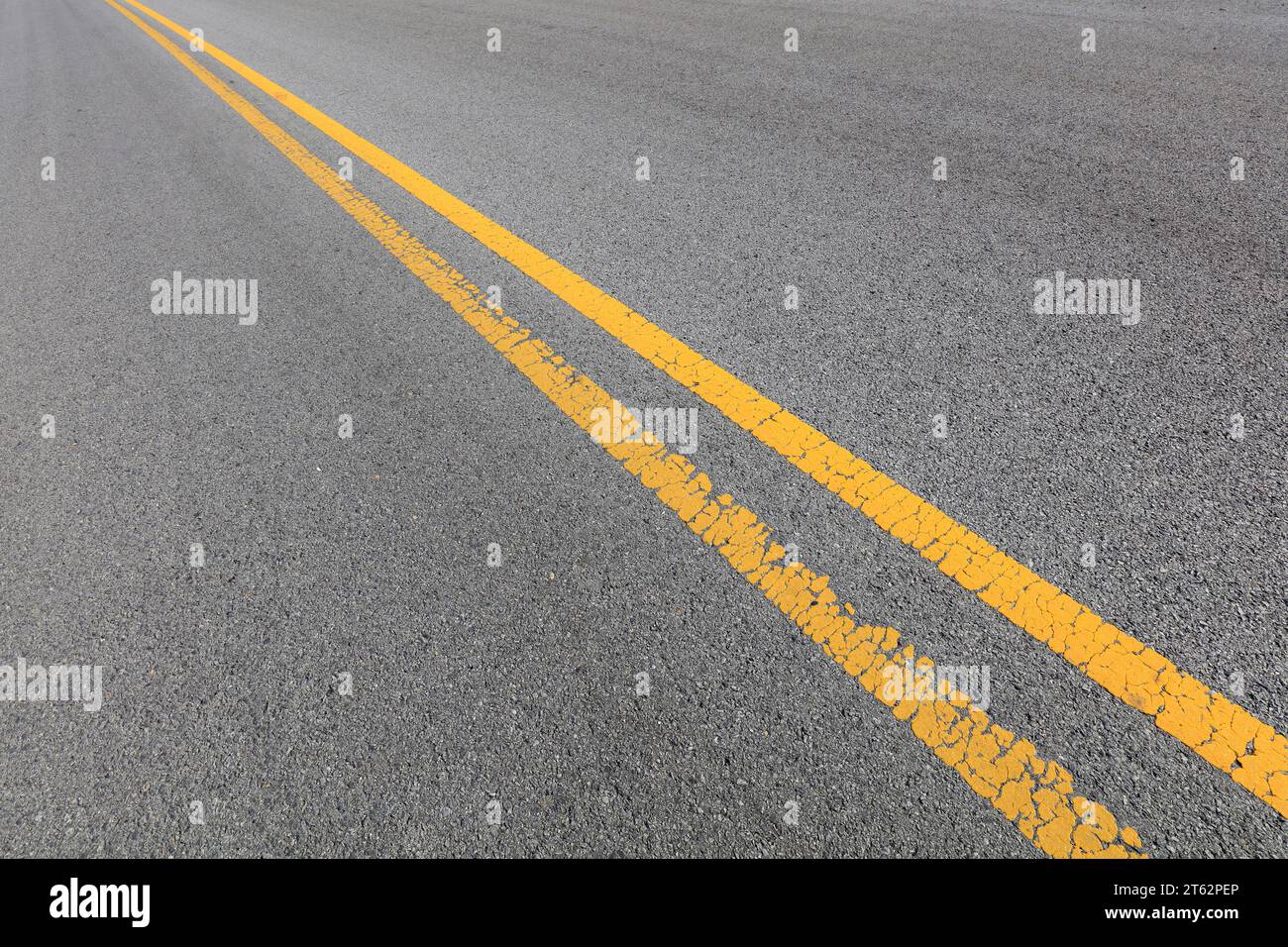 Yellow double solid line on the asphalt road Stock Photo - Alamy