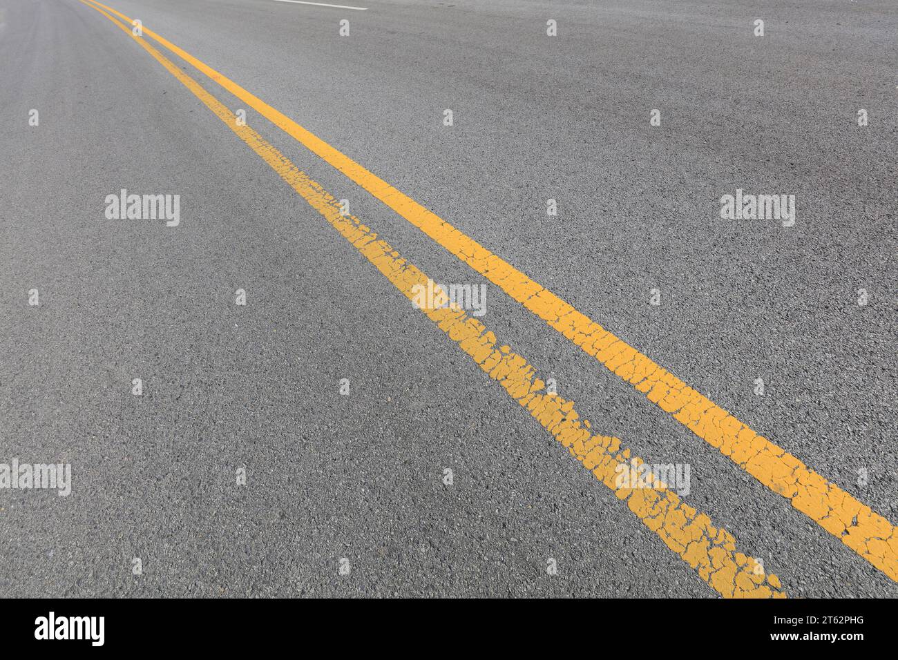 Yellow double solid line on the asphalt road Stock Photo - Alamy