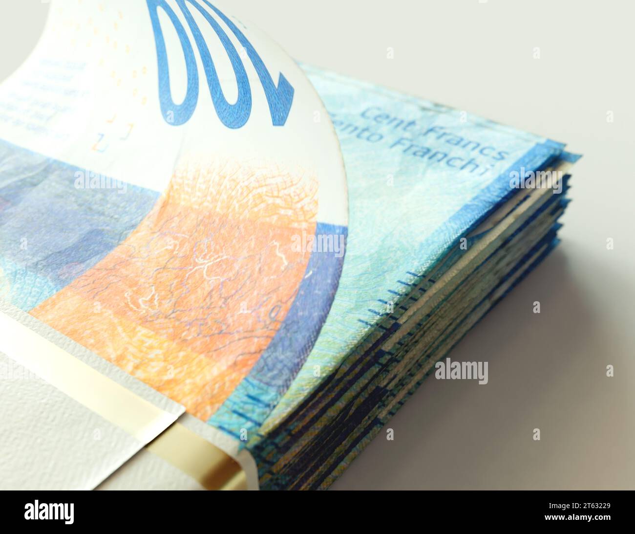 A bundled wad of Swiss Franc banknotes on an isolated light background ...