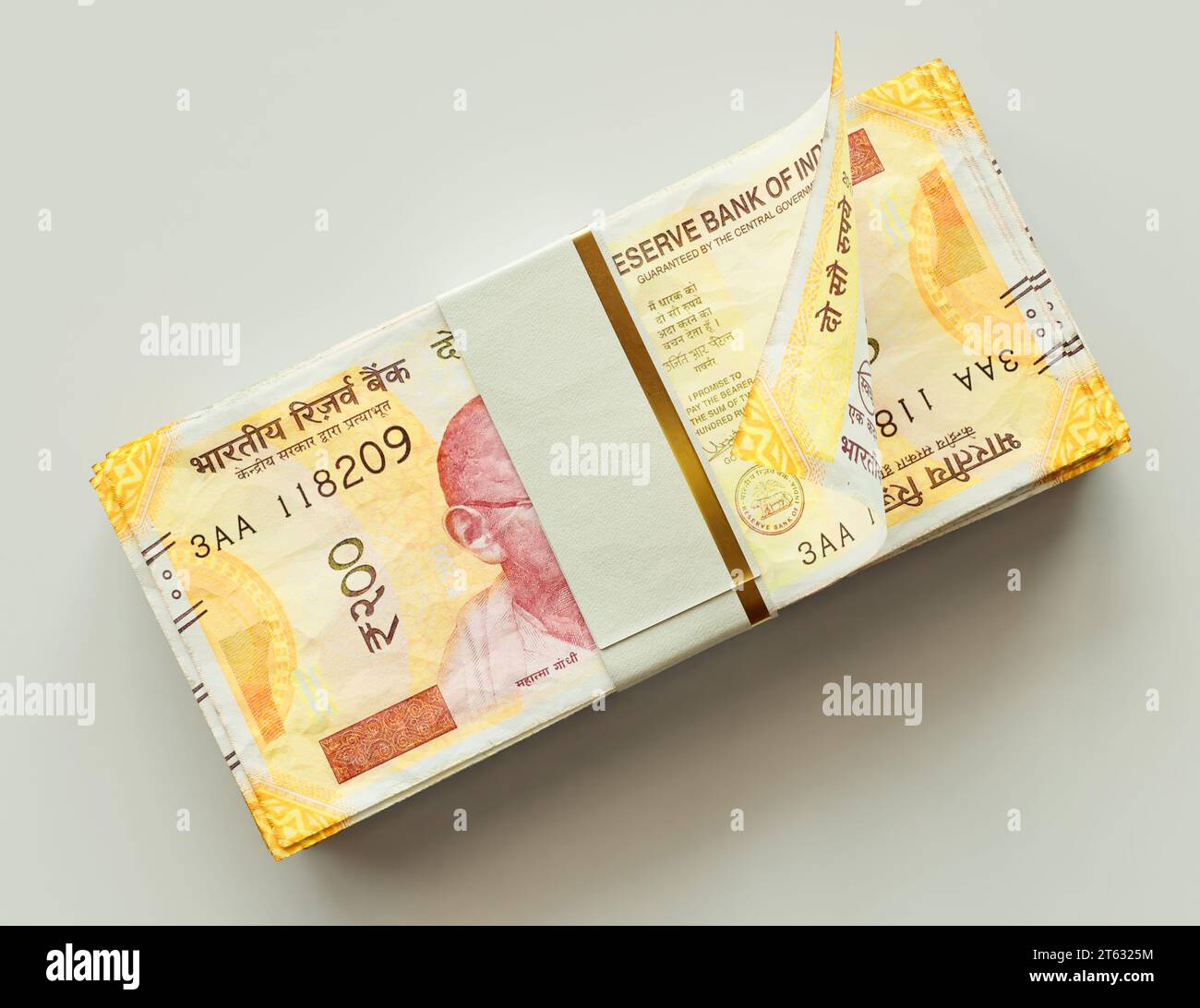 A bundled wad of India Rupee banknotes on an isolated light background ...