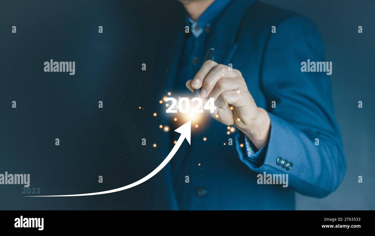 Businessman hand drawing line for increasing arrow from 2023 to 2024 ...