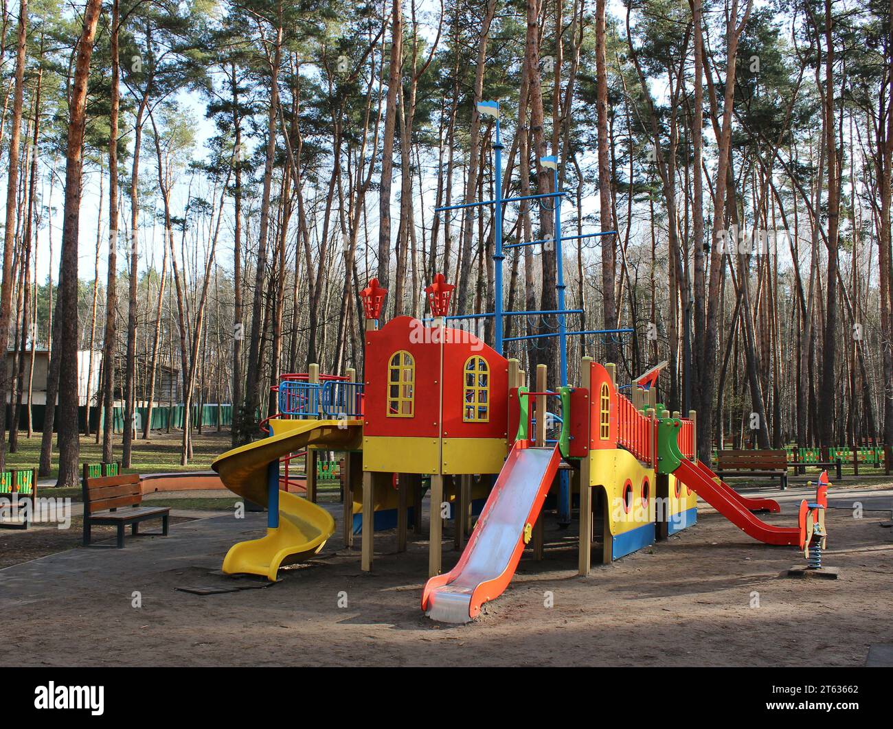 Empty open air colored play park with straight and spiral slides for ...