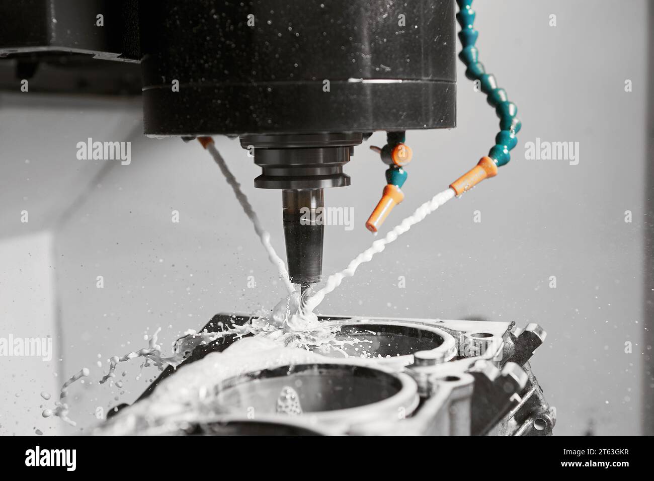 CNC milling machine grinds holes in car engine with coolant. Process of ...